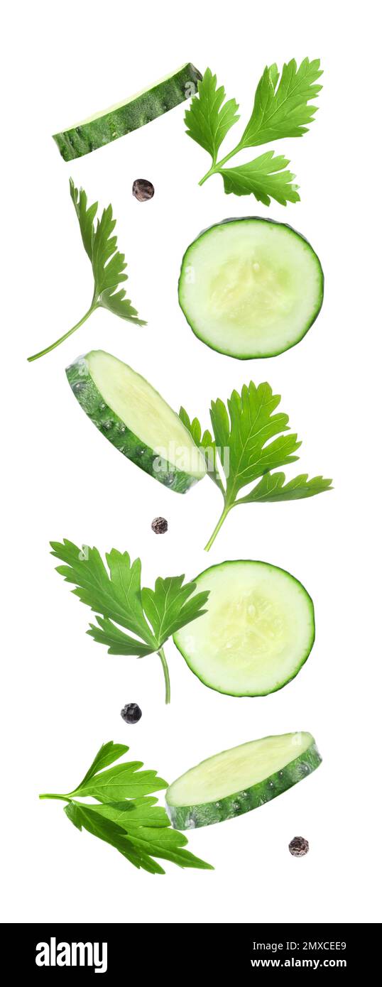 Set of flying fresh cucumber slices and other ingredients on white ...