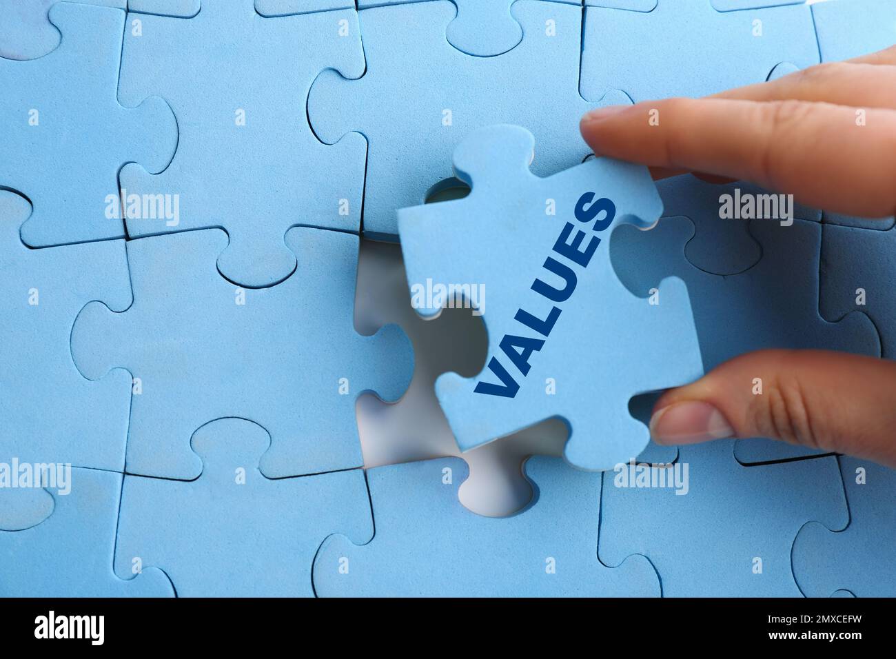 Core values concept. Woman putting light blue puzzle together, closeup ...