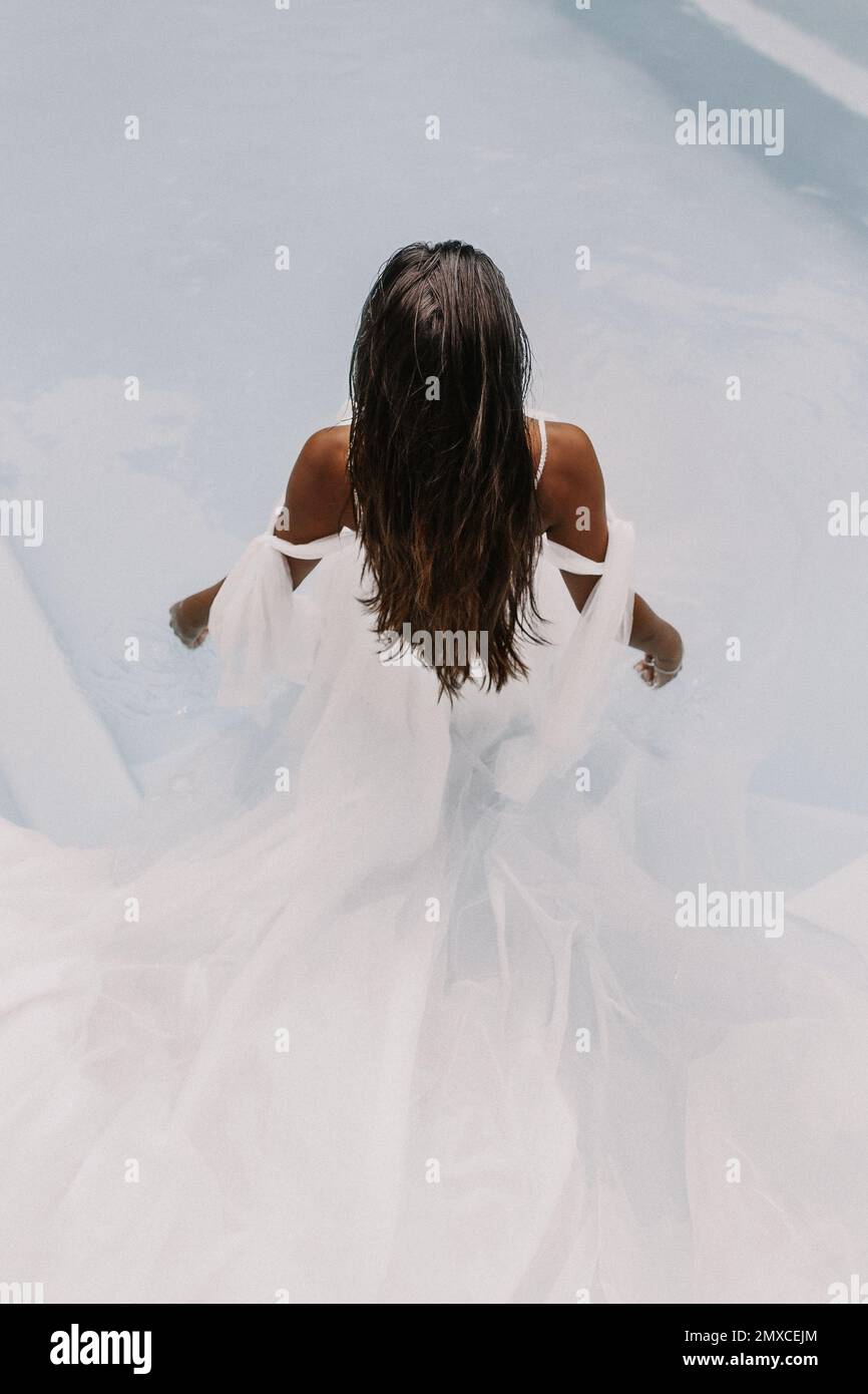 A back view of a bride wearing an elegant white wedding dress Stock ...