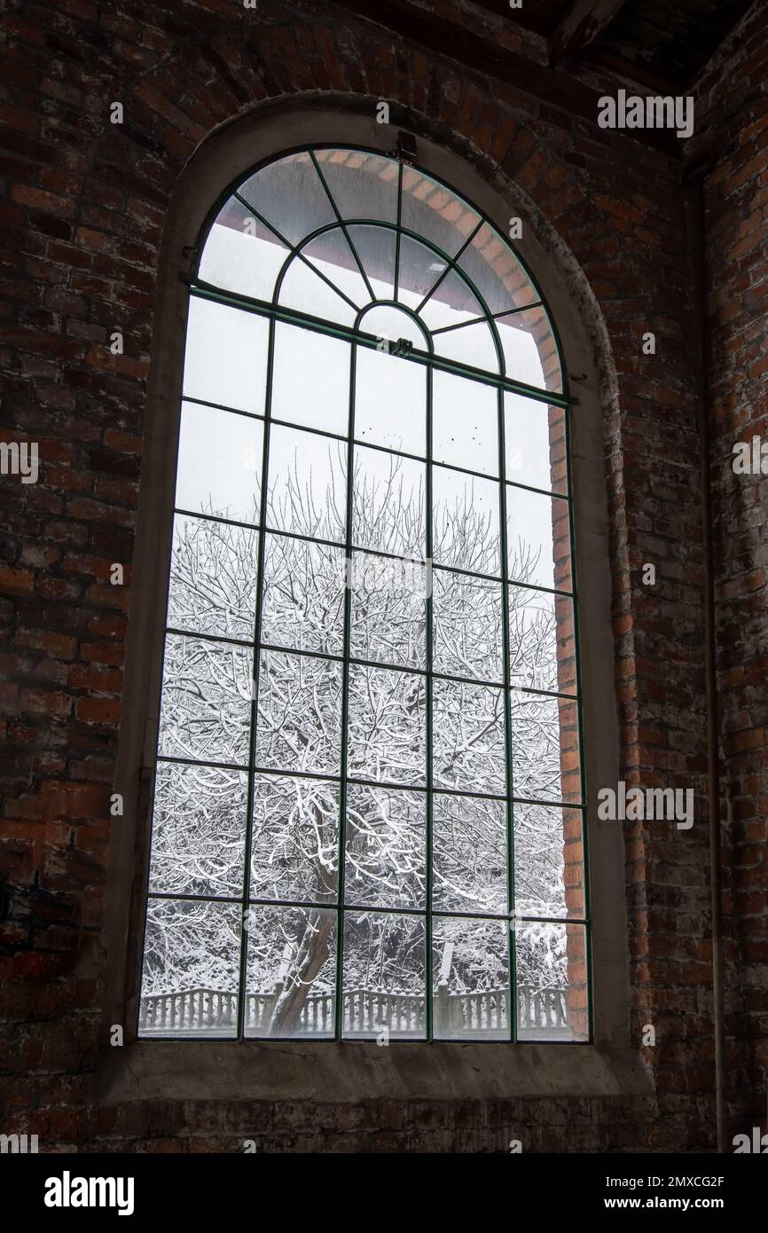 Big, arcade window with muntins in a shabby, brick wall. Industrial ...