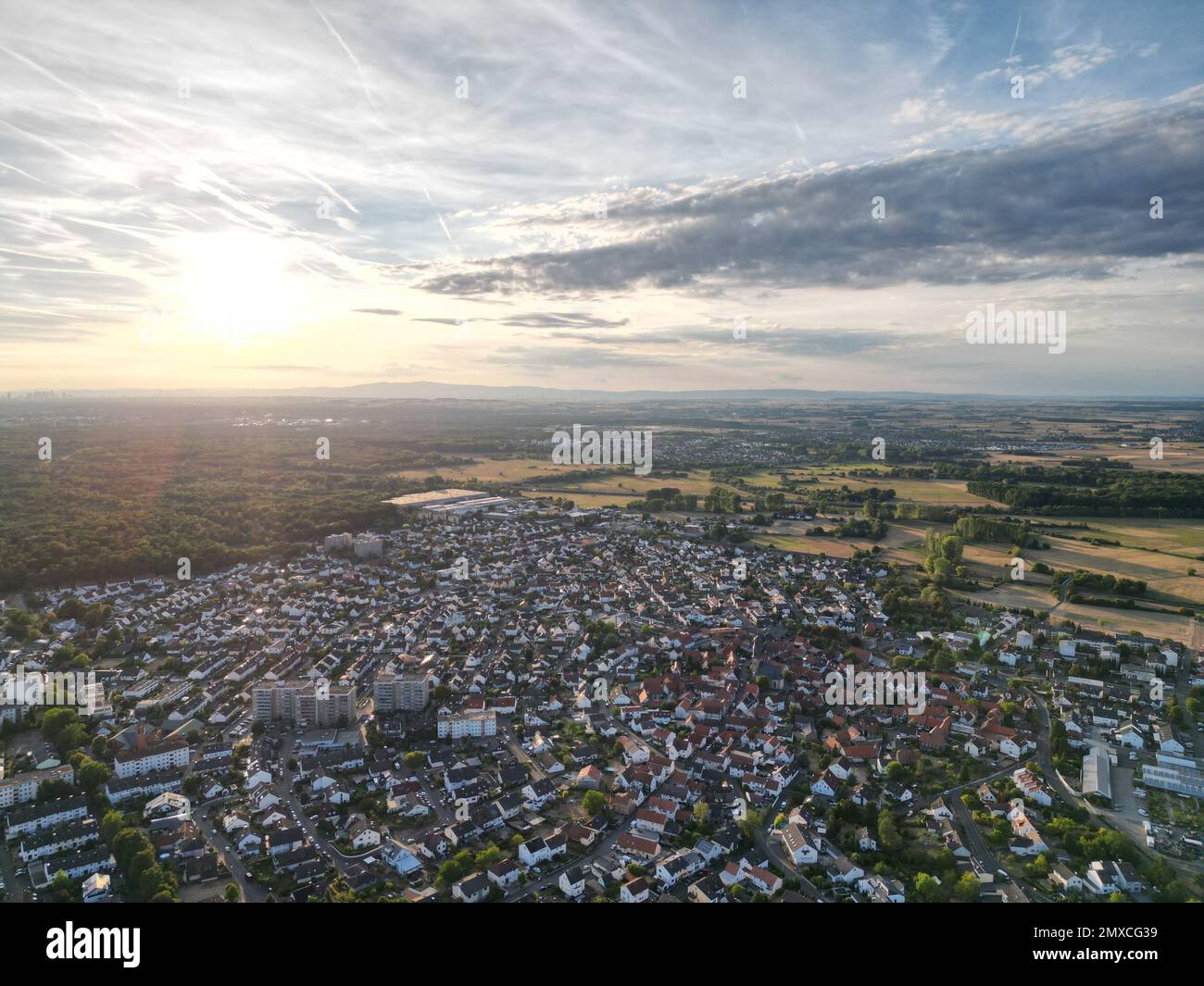 An aerial view of a city located in an open field with the sun about ...
