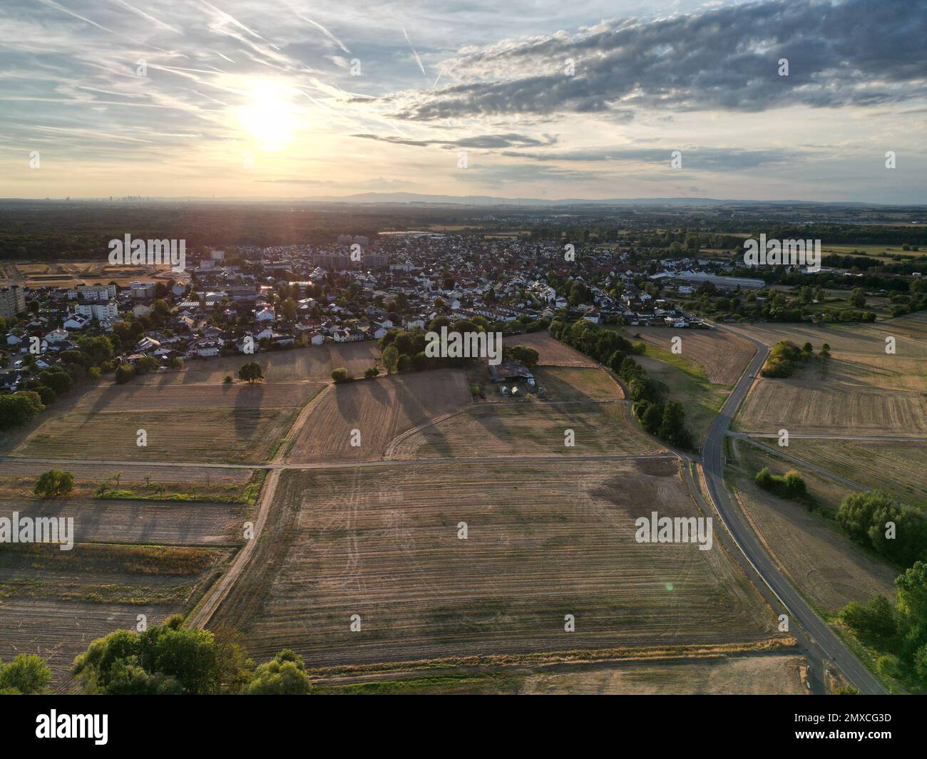 An aerial view of a city located in an open field with the sun about ...