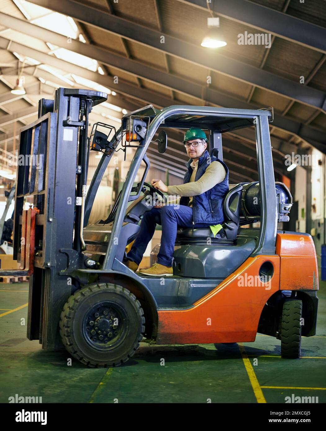 I get things moving around here. Portrait of driver in a forklift on ...