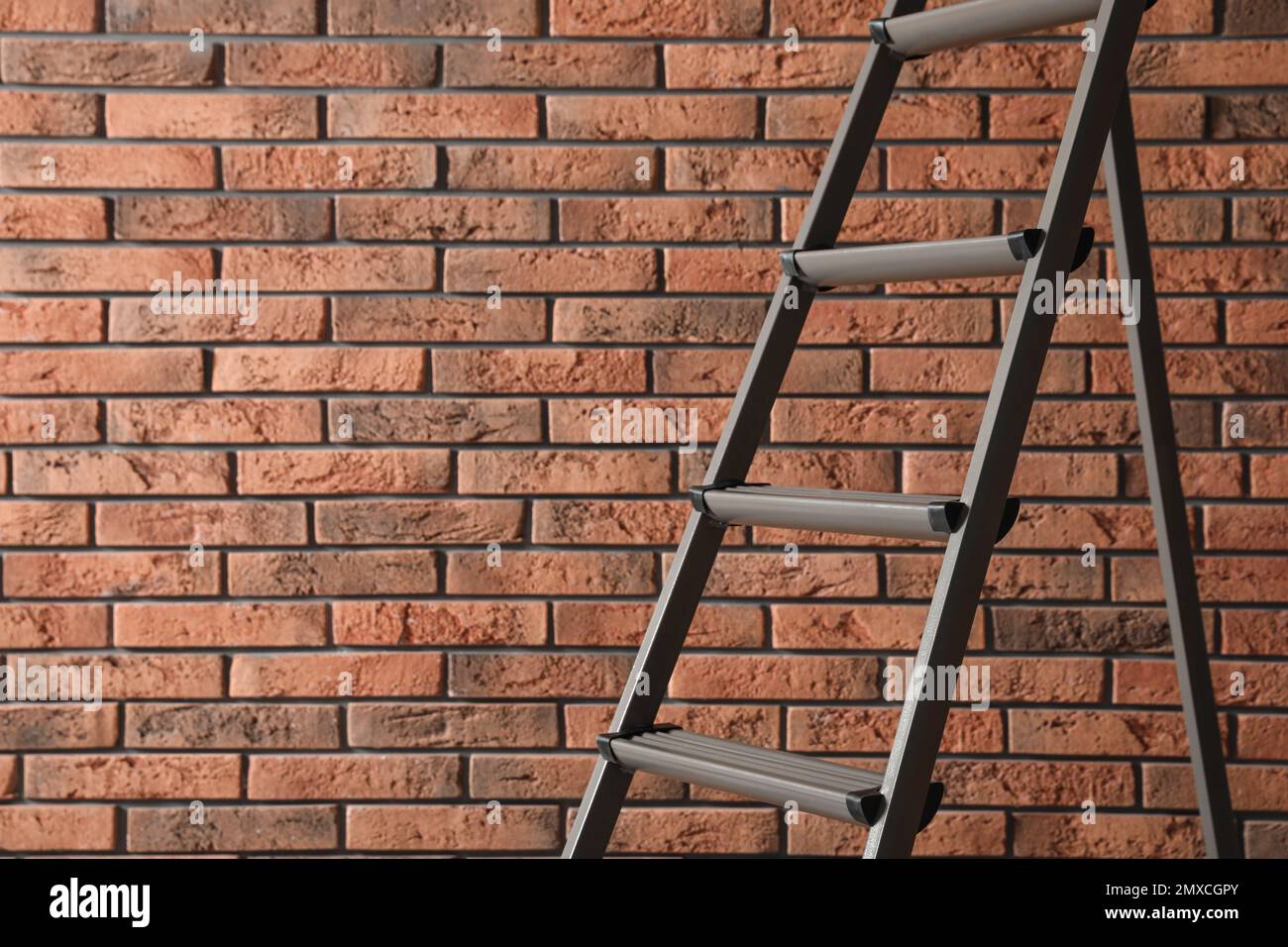 Metal step ladder near brick wall, closeup. Space for text Stock Photo ...