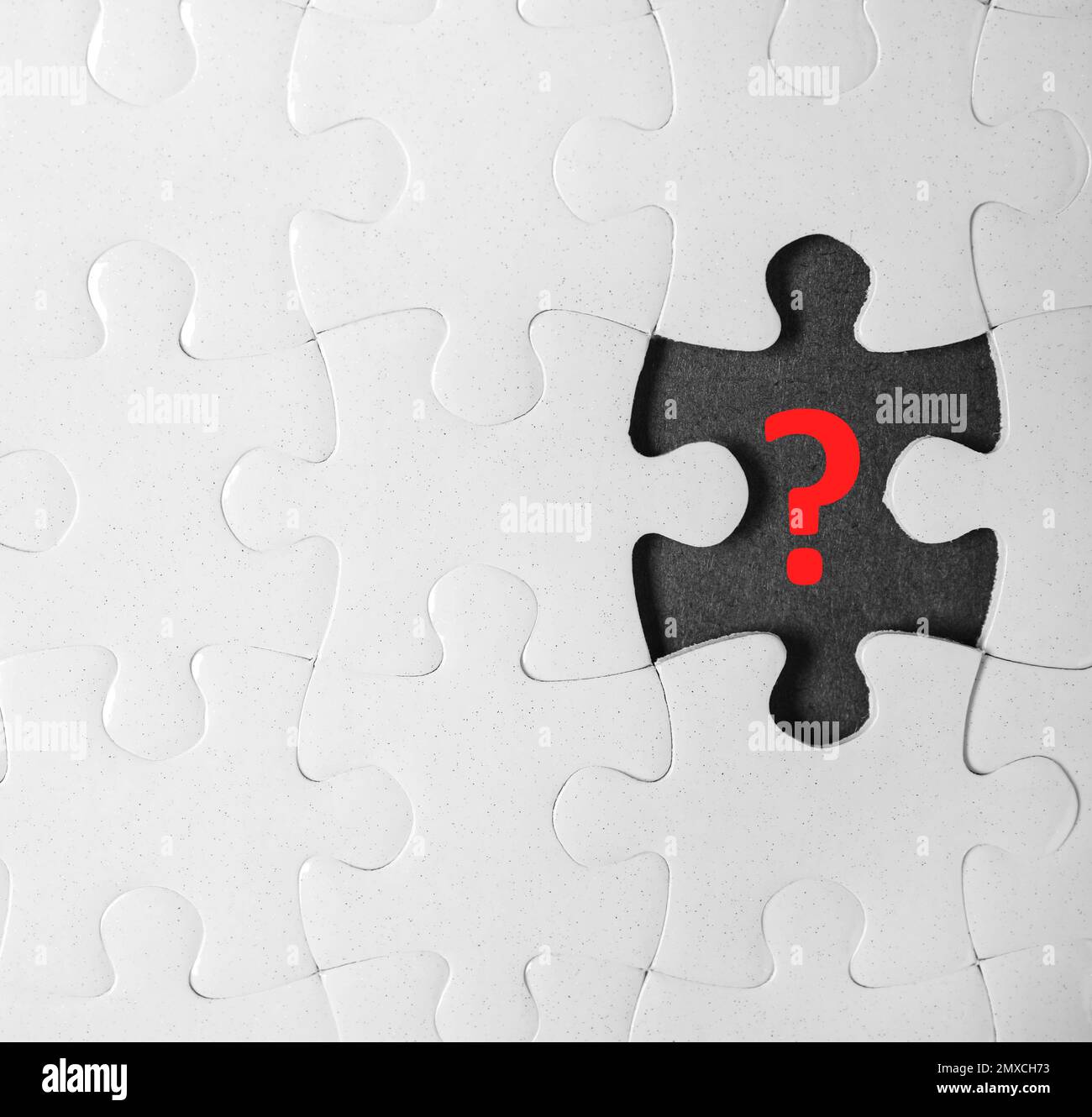 White puzzle with missing piece and question mark on black background ...