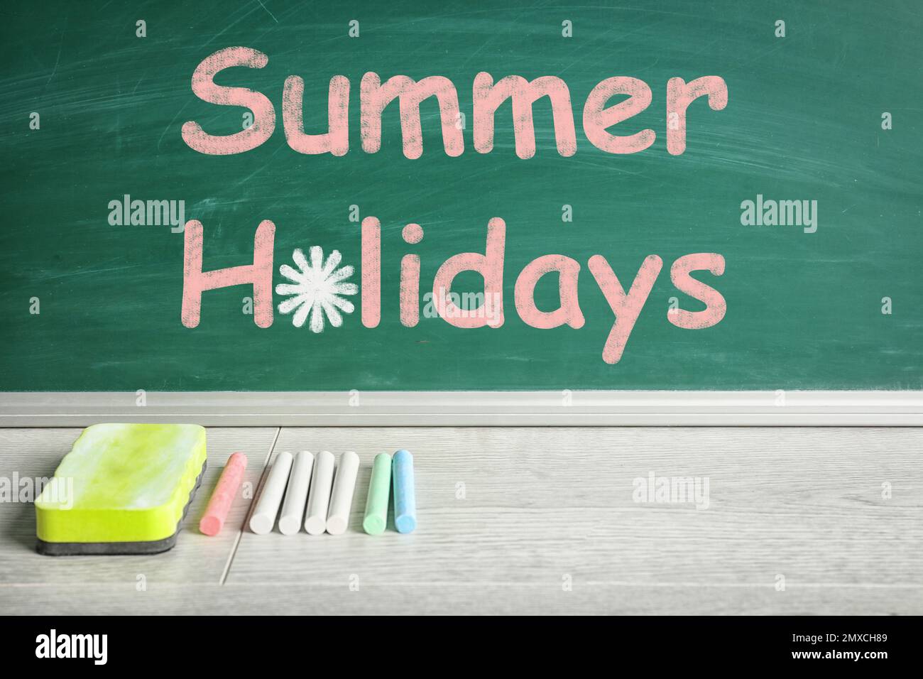 Chalk and duster near greenboard with inscription Summer Holidays ...