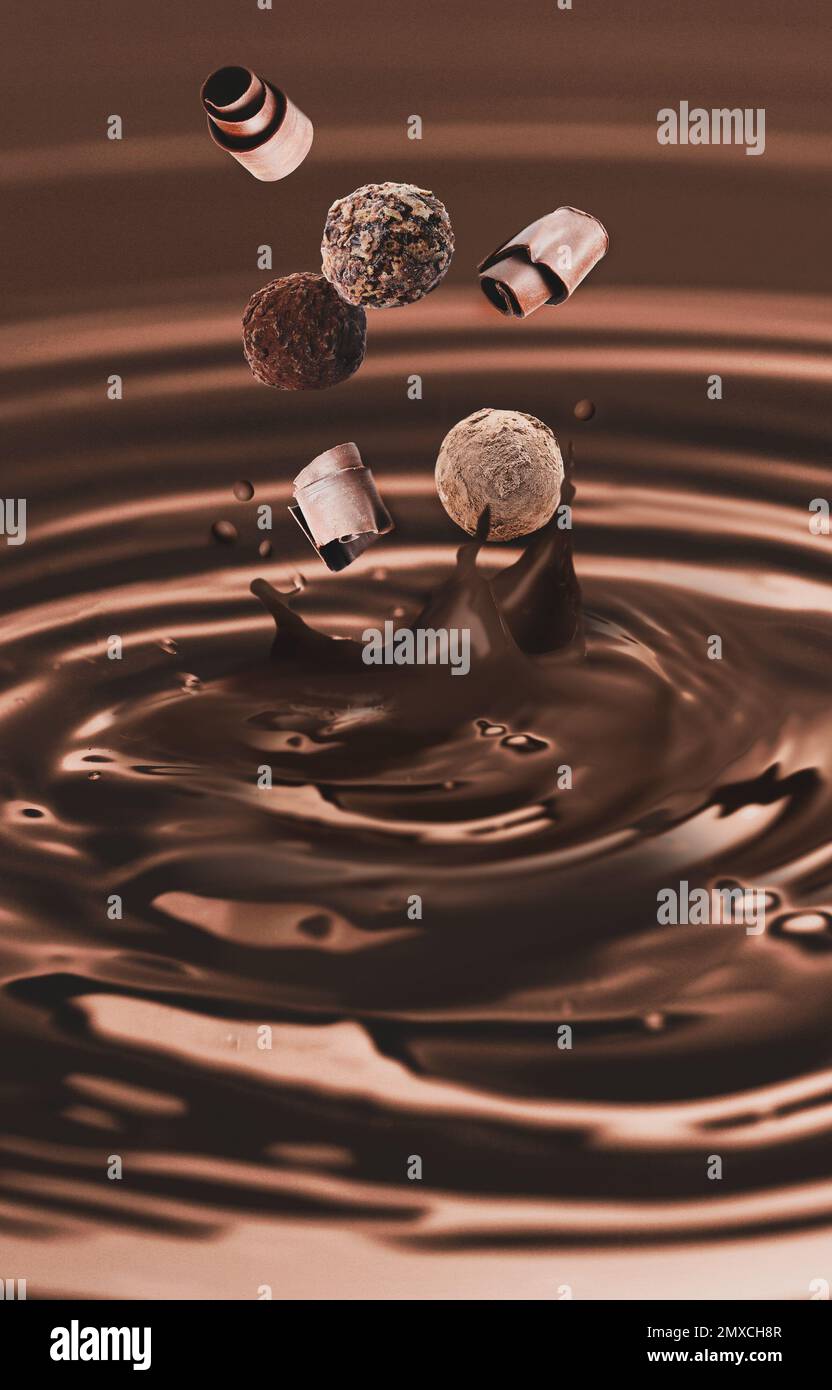 Yummy melted chocolate splashing with falling curls and candies Stock ...