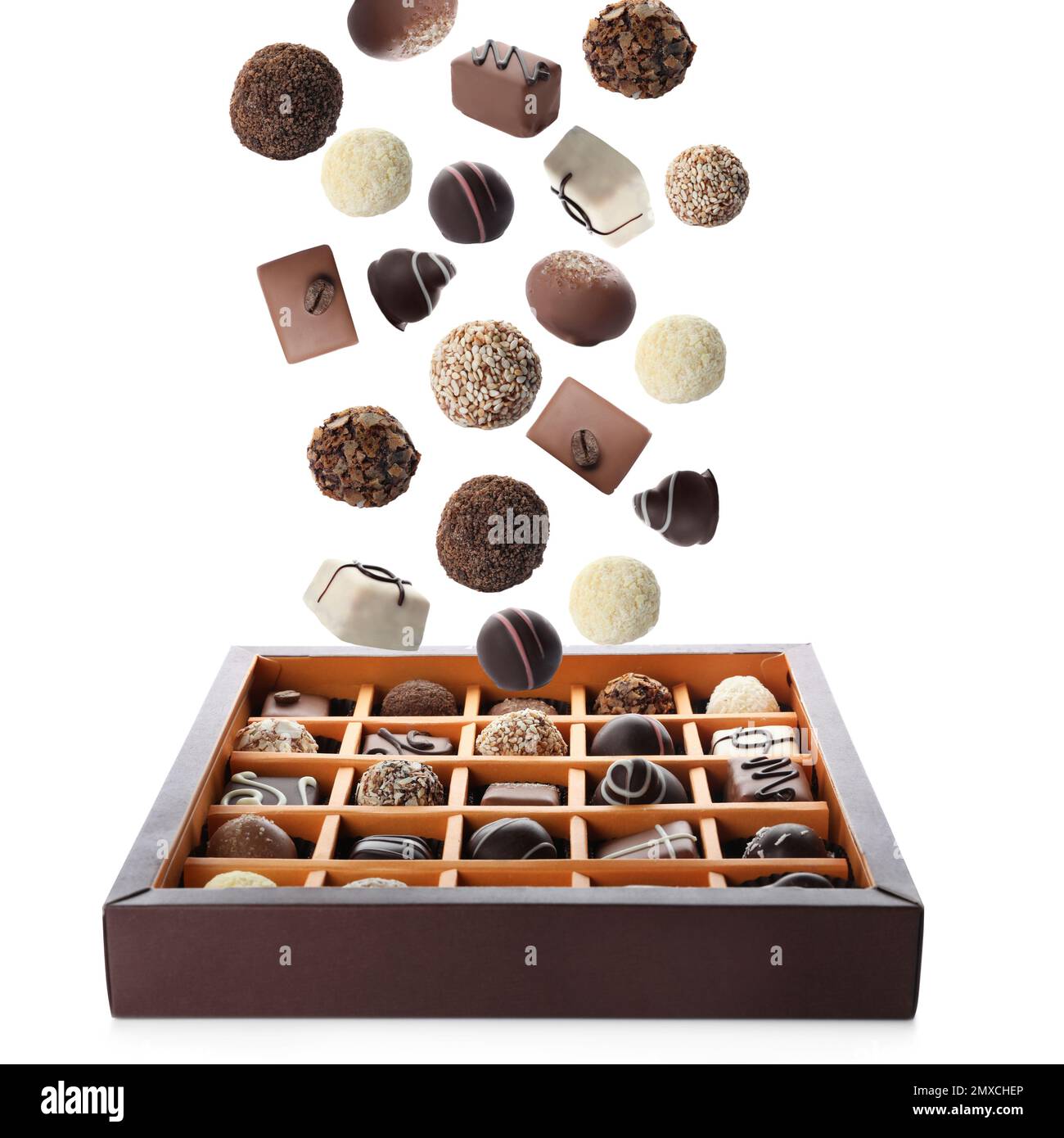 Chocolate candies falling into box on white background Stock Photo - Alamy