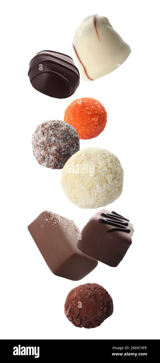 Different chocolate candies falling on white background Stock Photo - Alamy