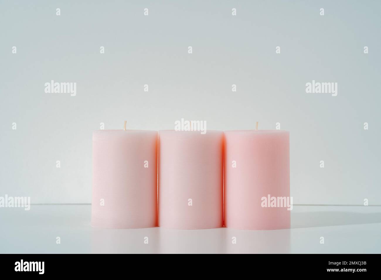 three new pink round candles in a row macro photo background. Cozy home ...