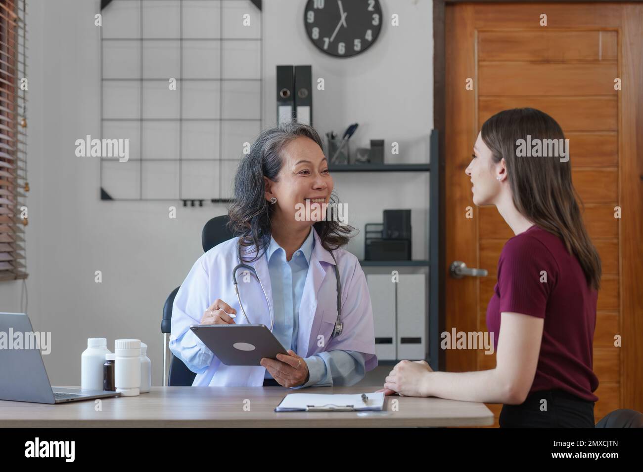 Senior Doctor and her patient. Doctor giving advice to a female patient ...