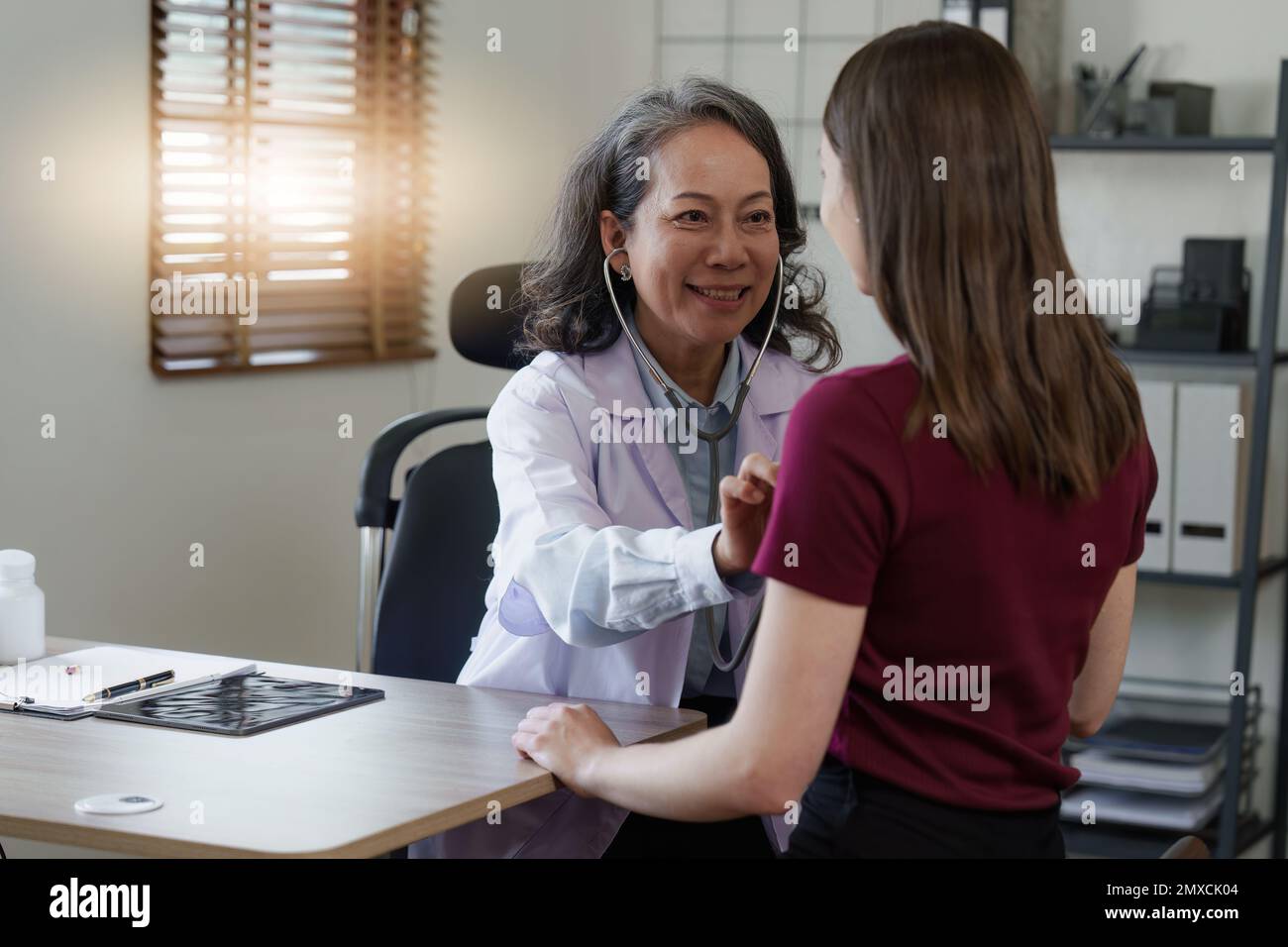 Senior Doctor and her patient. Doctor giving advice to a female patient ...