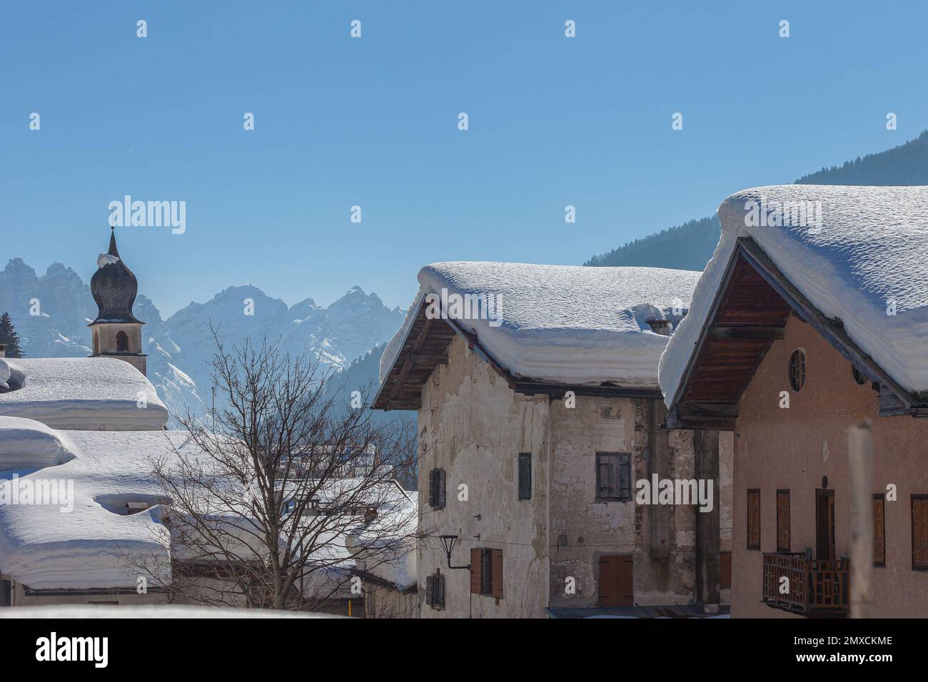 Houses in small Dolomite village with snow-covered roofs Stock Photo ...