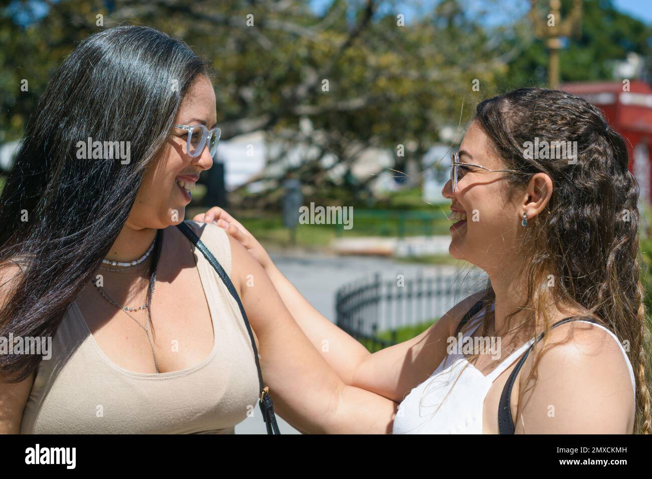 two young venezuelan latin women, tourists standing in a plaza in the ...