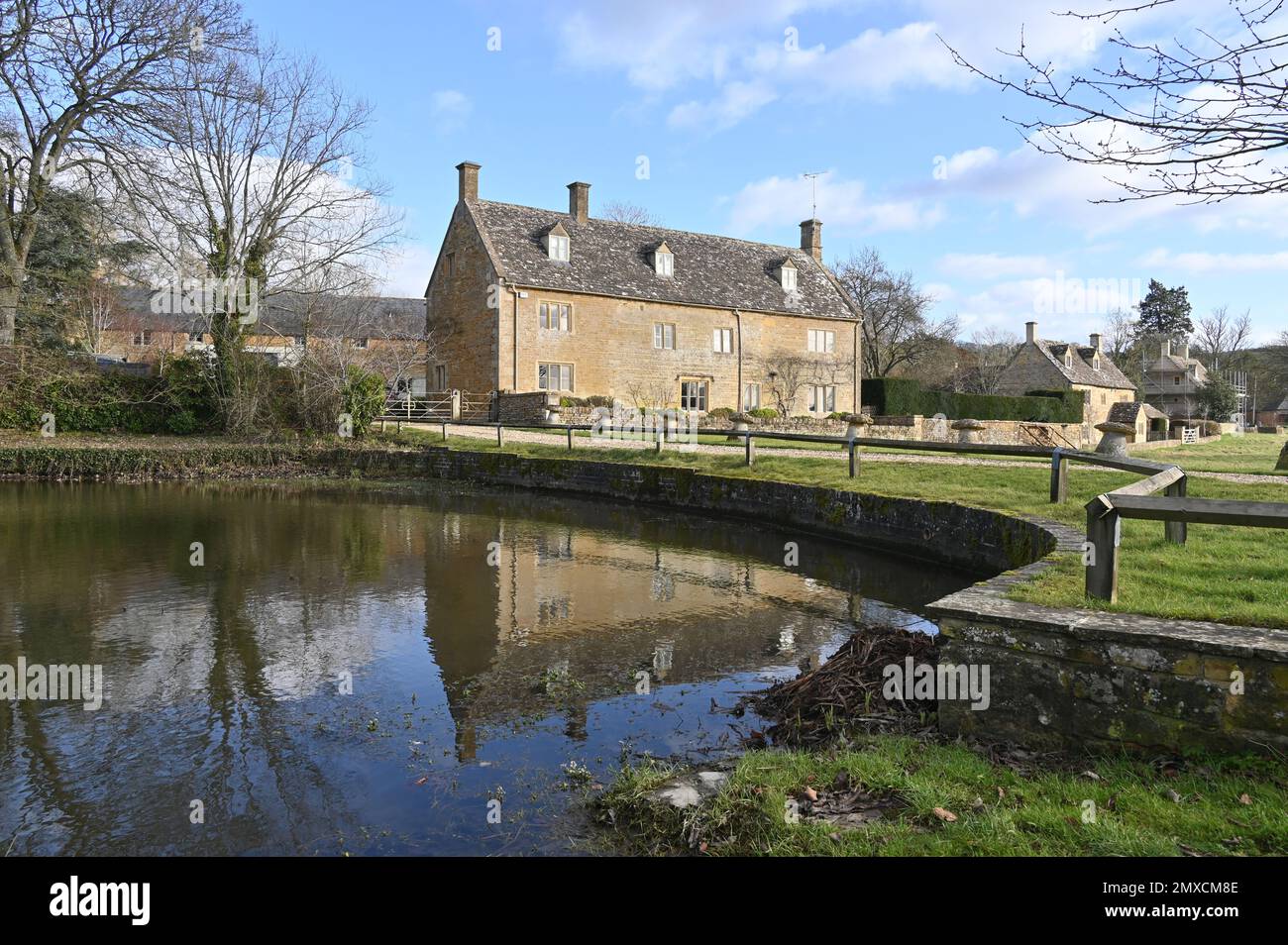 The village pond in the Cotswold village of Wyck Rissington ...