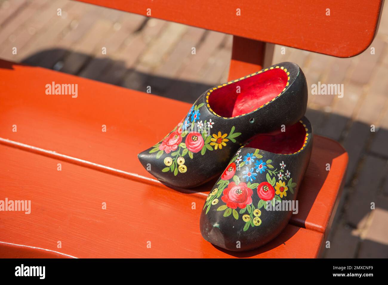 Traditional Dutch wooden shoes on a bench in the park. Selective focus ...