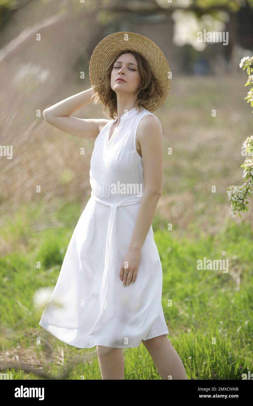 Spring fashion campaign. Outdoor portrait of female model in white ...