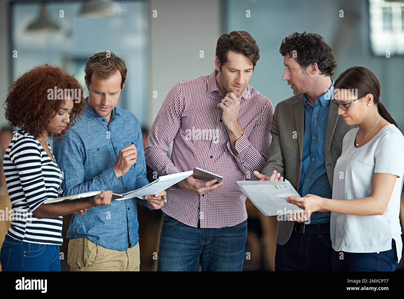We consider all the options. a group of coworkers standing in an office ...