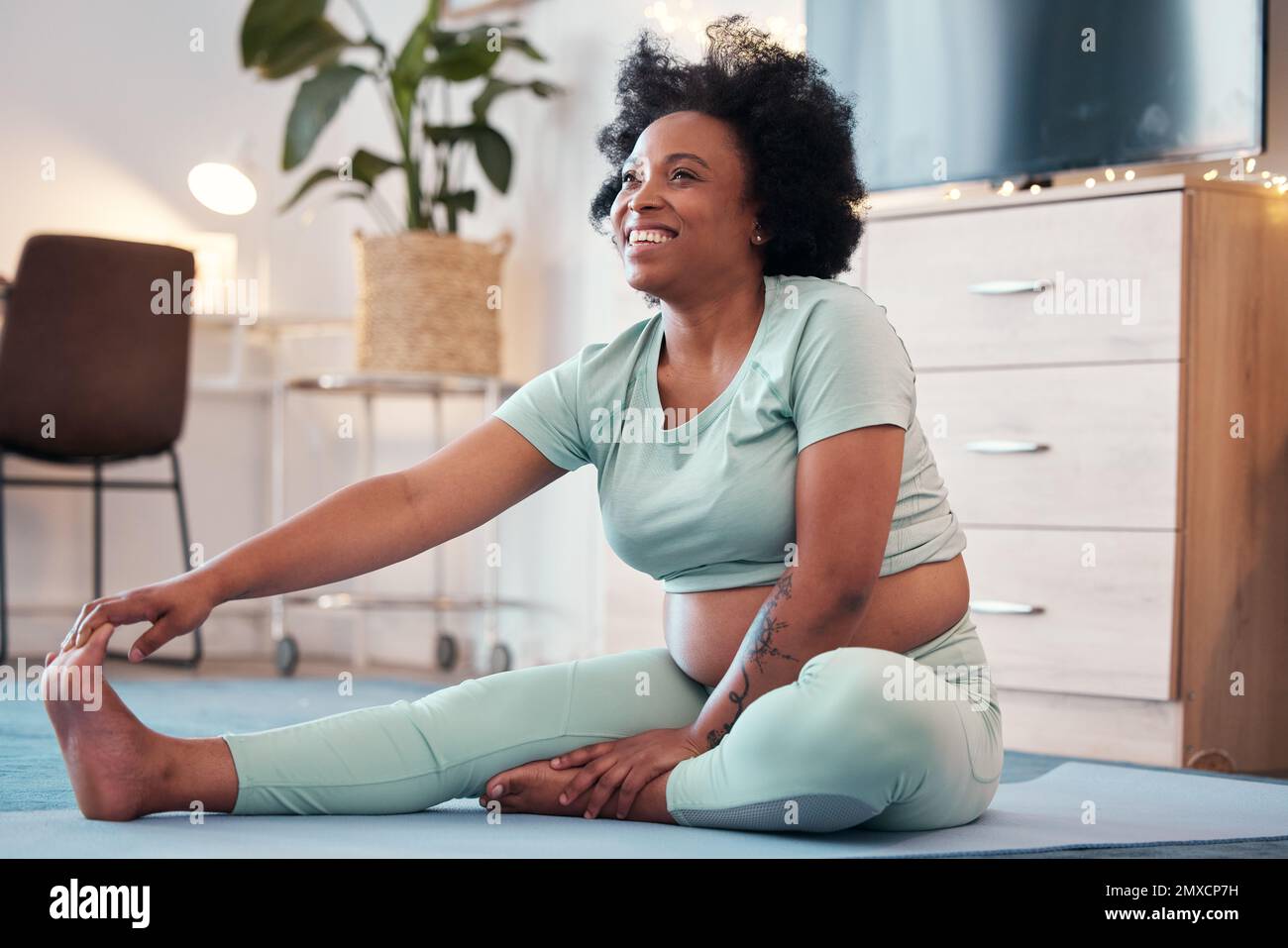 Yoga, pregnant and black woman stretching legs in home for flexibility ...