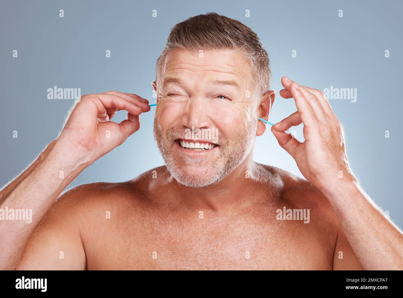 Earbuds, grooming and man cleaning his ears in a studio for self care ...