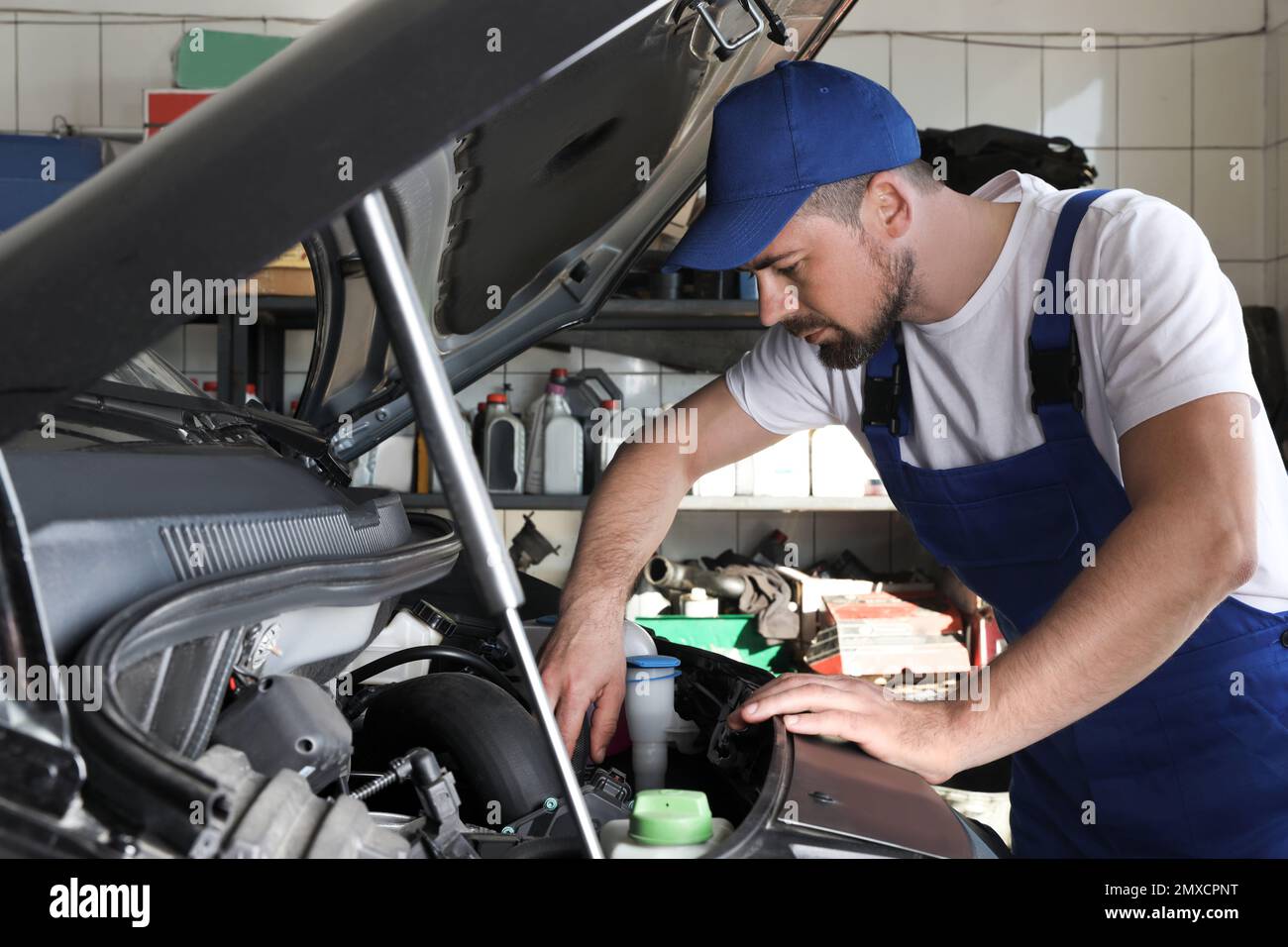 Professional auto mechanic fixing modern car in service center Stock ...