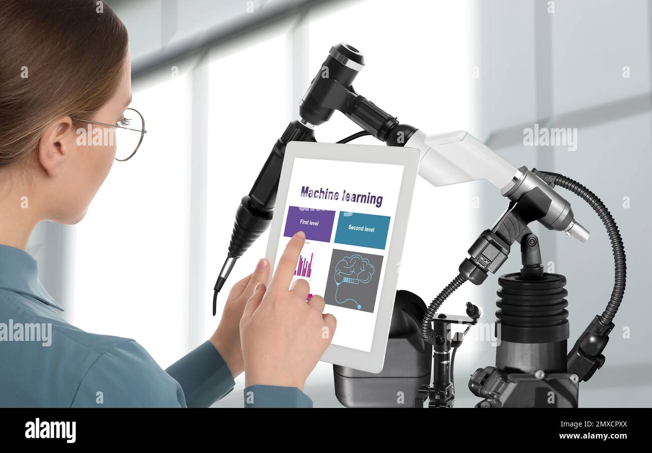 Engineer controlling electronic laboratory robot manipulator with ...