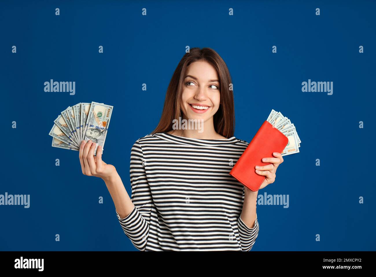 Happy young woman with cash money and wallet on blue background Stock ...