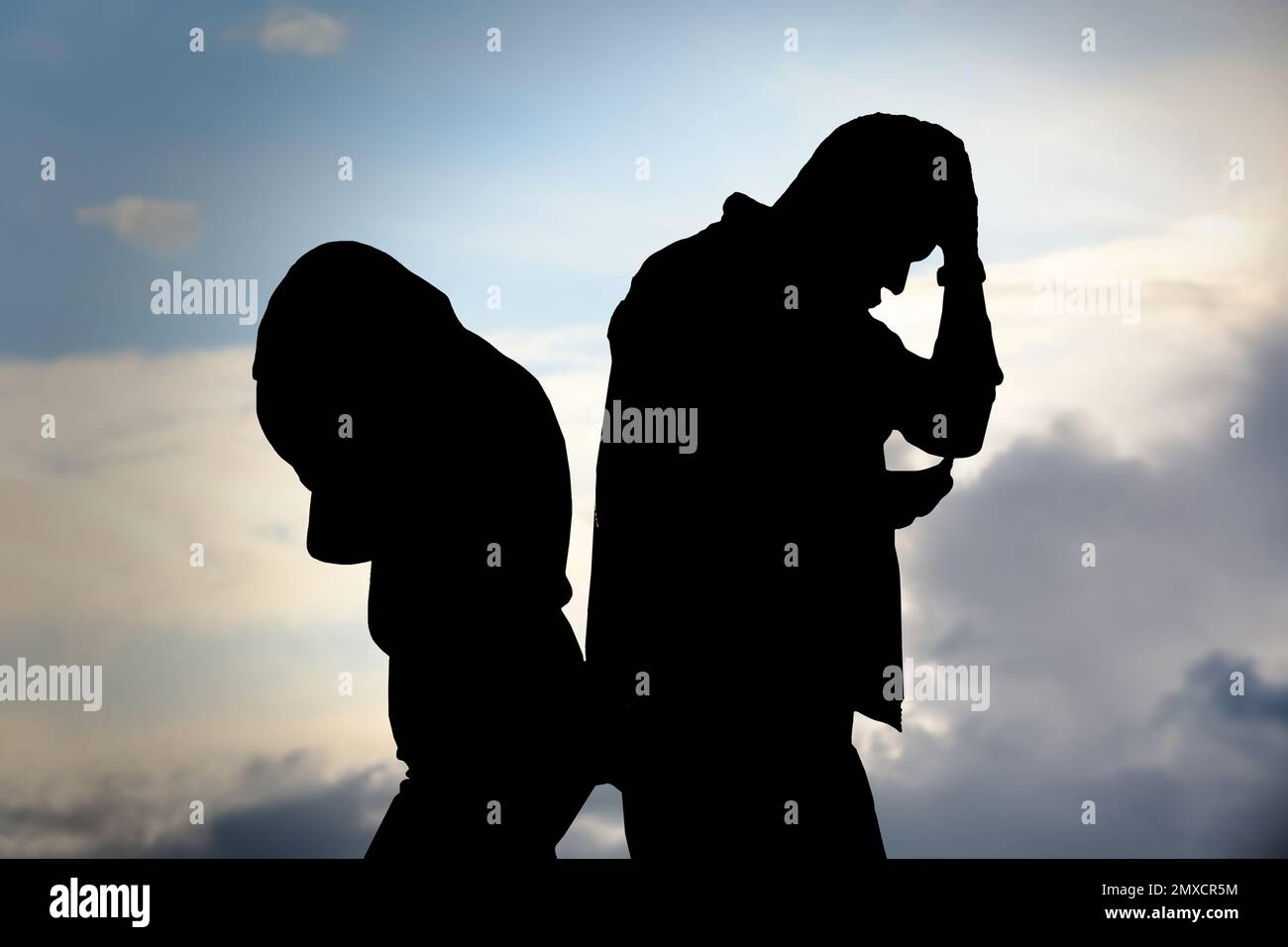 Silhouettes of arguing couple against cloudy sky. Relationship problems ...