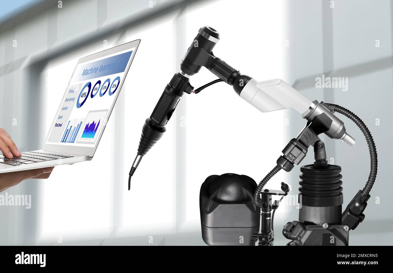 Engineer controlling electronic laboratory robot manipulator with ...