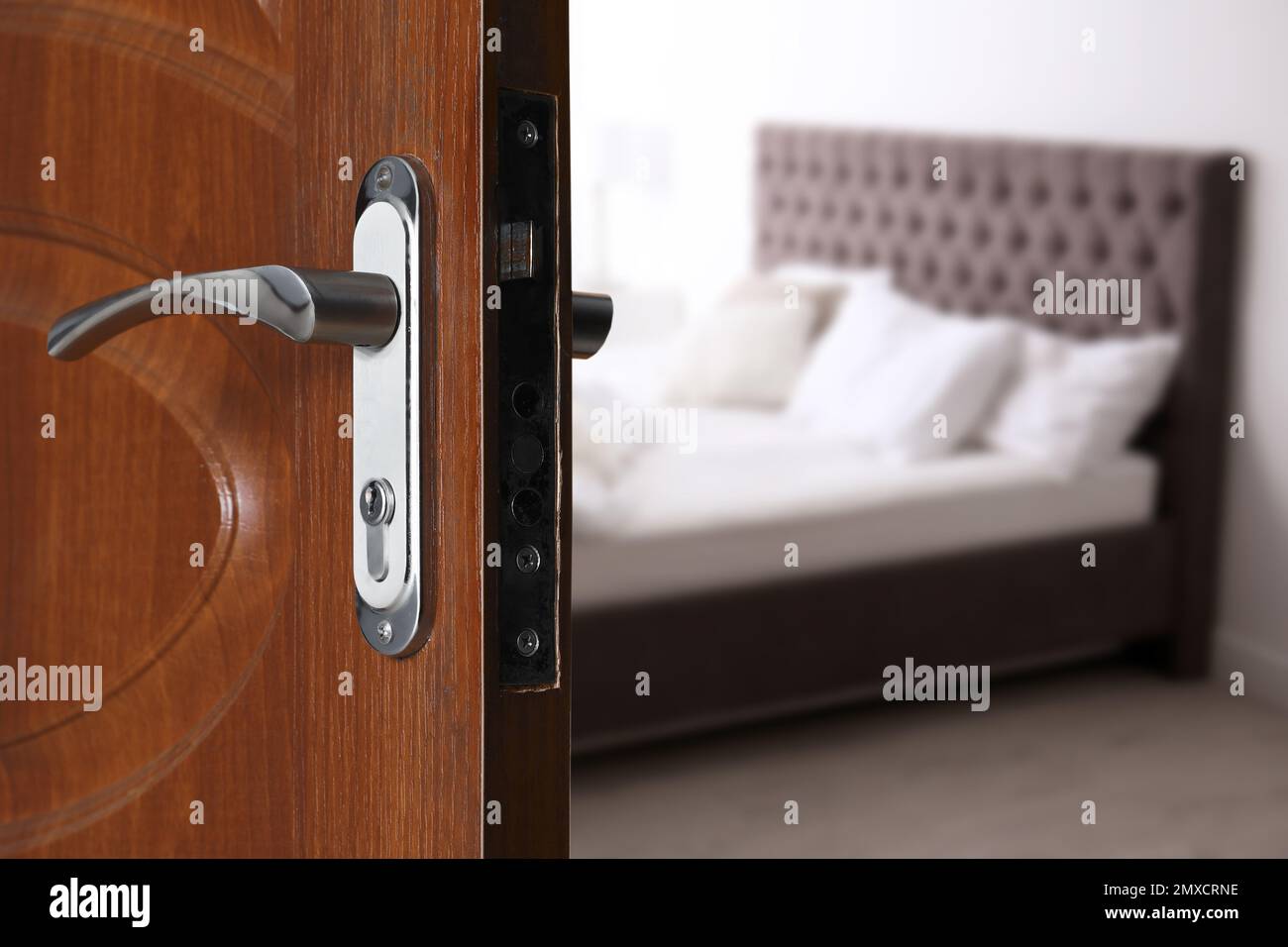 Wooden door open into modern hotel room, closeup Stock Photo - Alamy