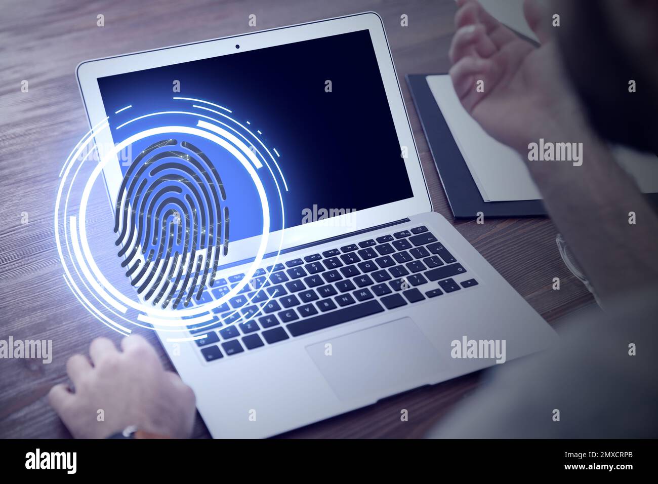 Fingerprint identification. Man working with laptop at table, closeup ...
