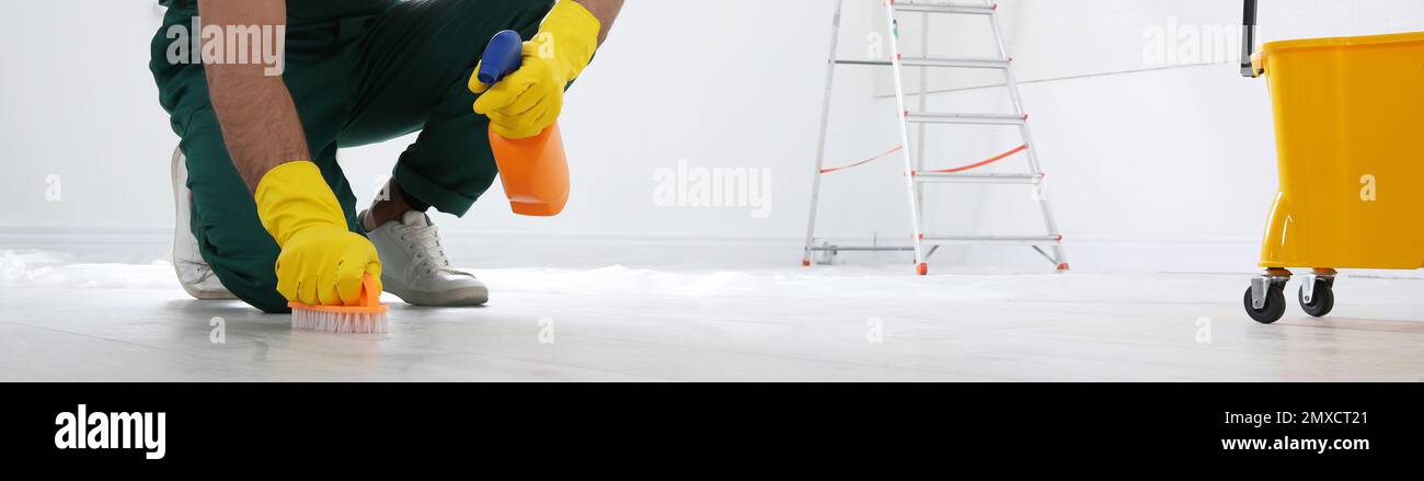 Professional janitor cleaning floor with brush and detergent, closeup ...