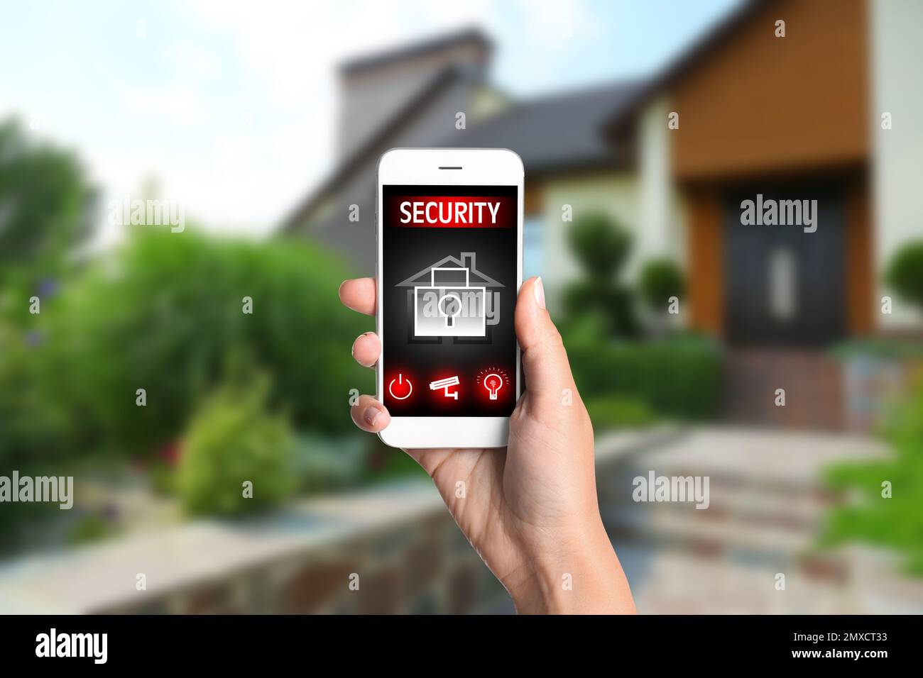 Woman monitoring modern CCTV cameras on smartphone near her house ...