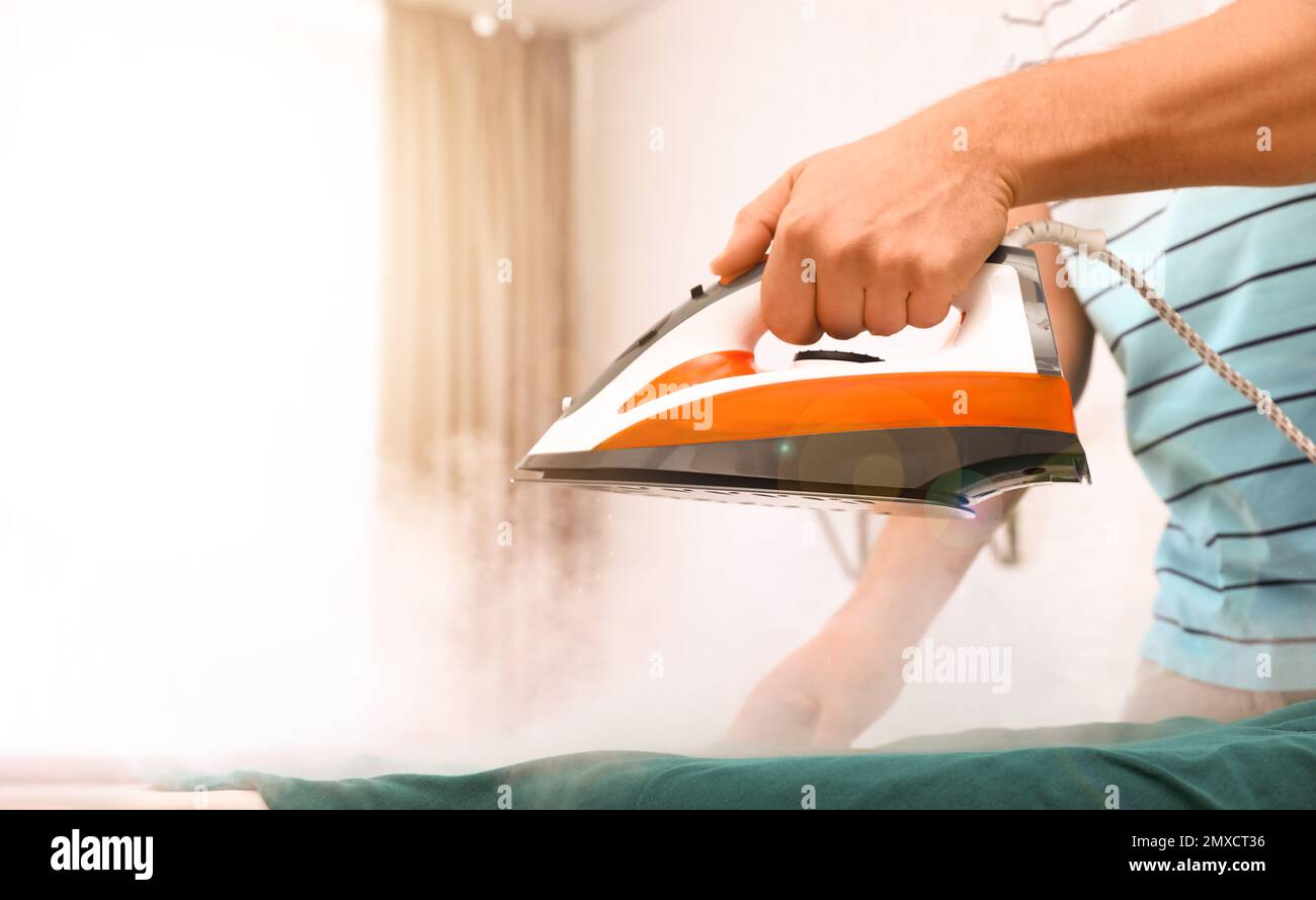 Man ironing clothes hi-res stock photography and images - Alamy