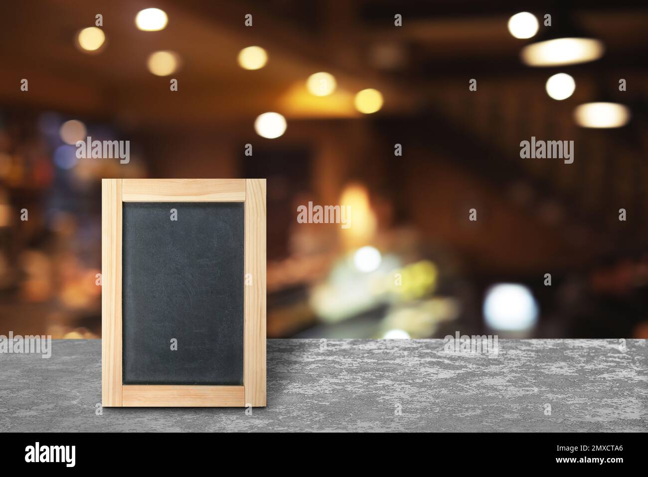 Blank small blackboard on wooden table in cafe, mockup for menu design ...