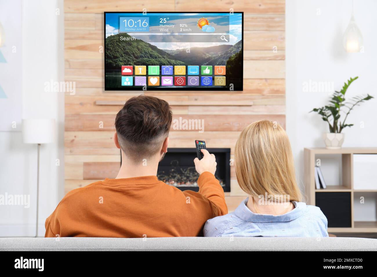 Couple watching smart TV on sofa in living room Stock Photo - Alamy