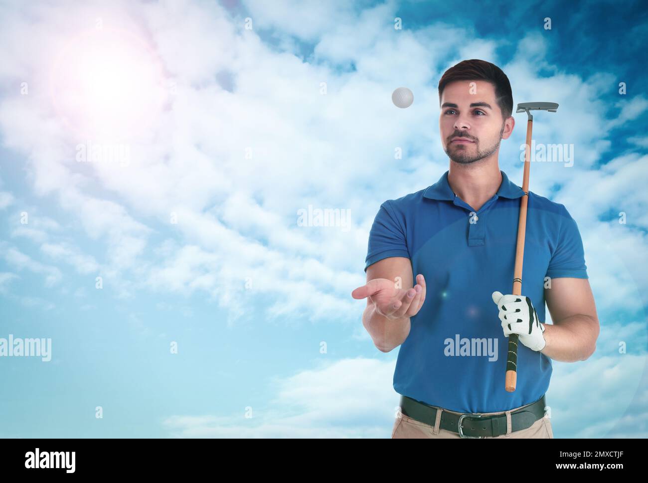 Young man with golf club and ball against blue sky. Space for design ...