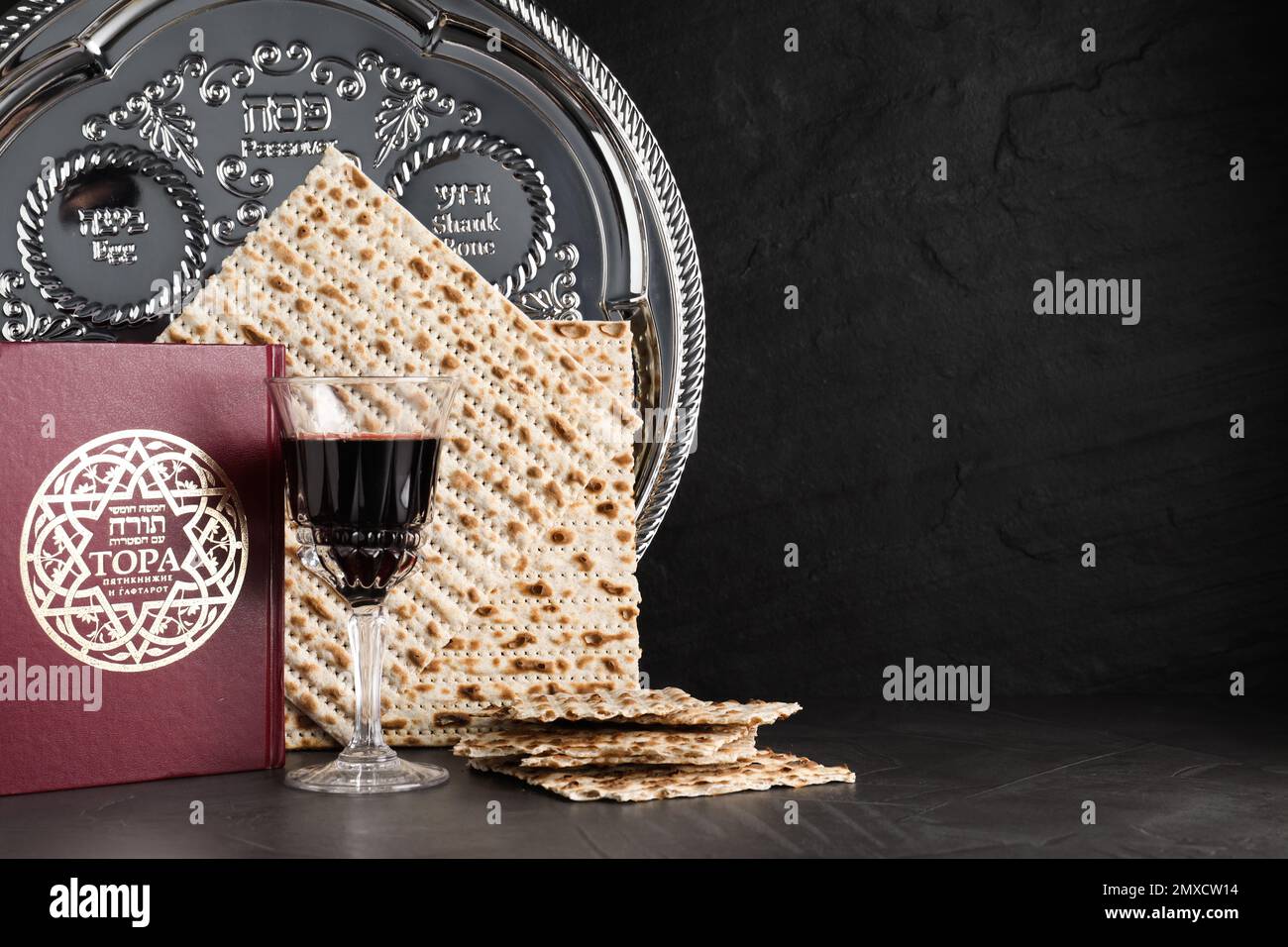 Symbolic Pesach (Passover Seder) items on black table, space for text ...
