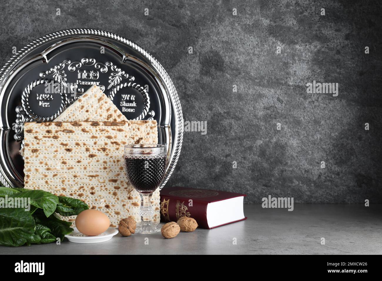 Symbolic Pesach (Passover Seder) items on grey table. Space for text ...