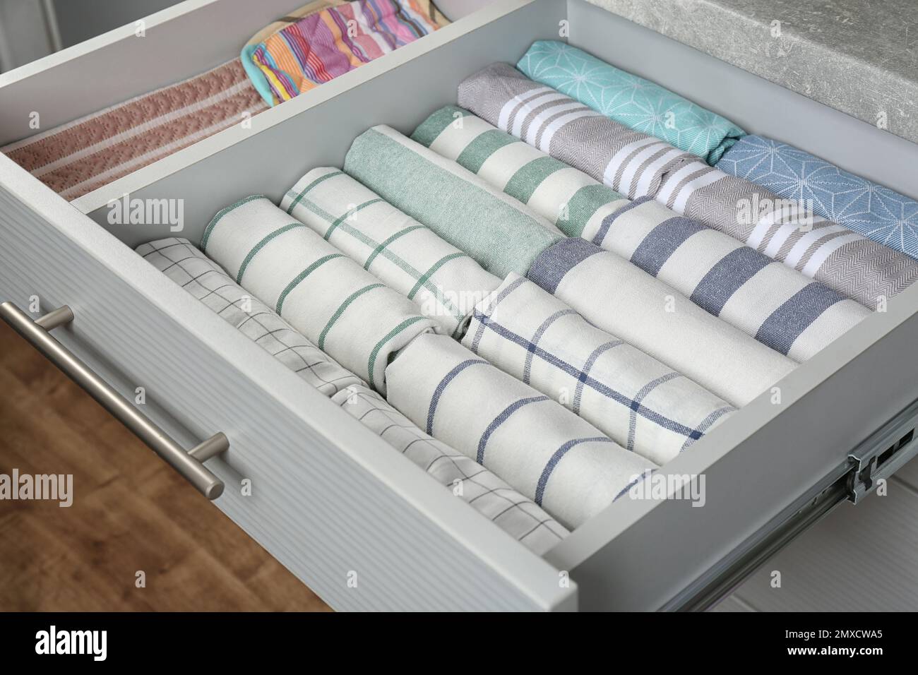 Open drawer with folded towels. Order in kitchen Stock Photo - Alamy