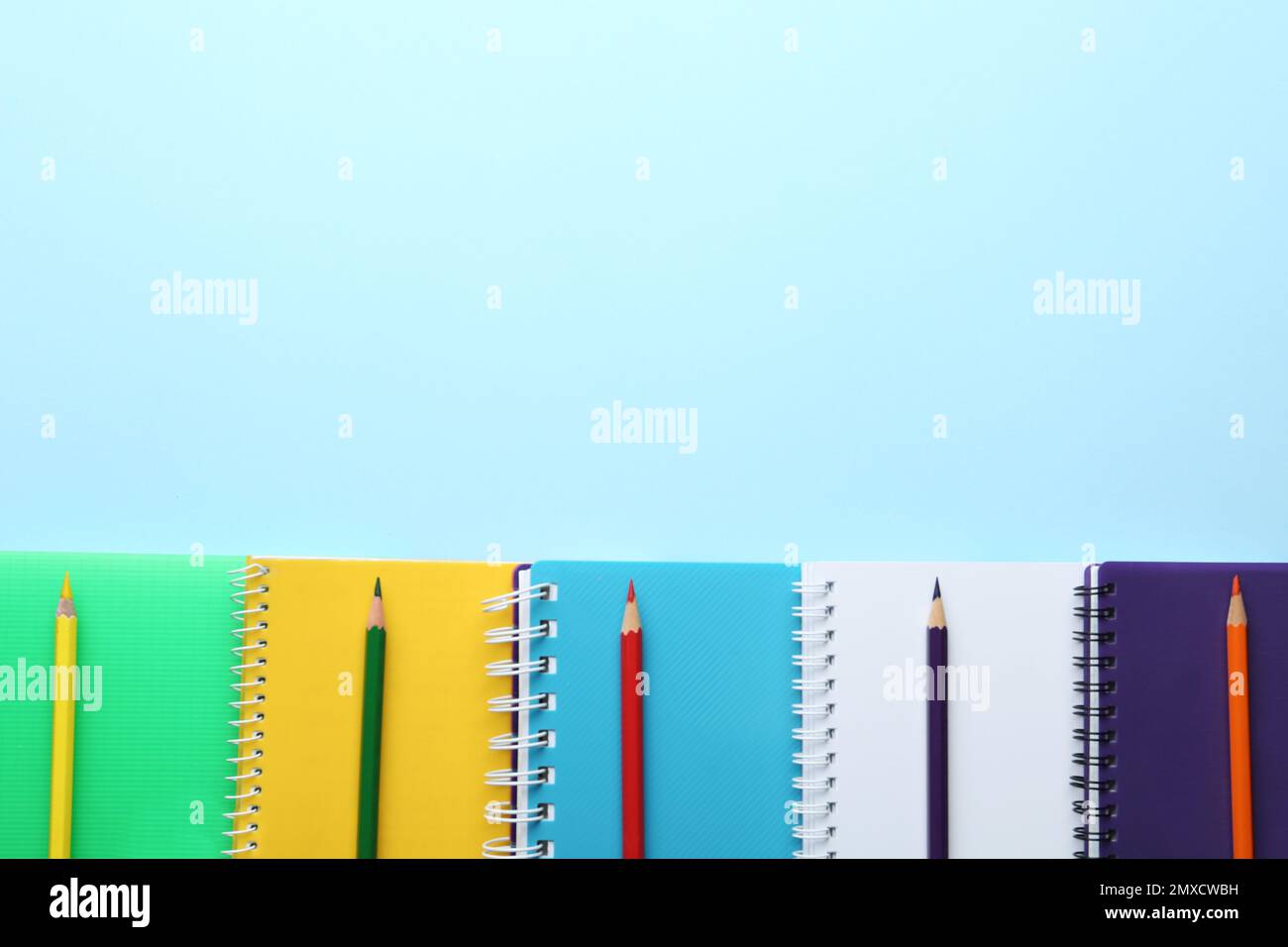 Stylish notebooks and pencils on light blue background, flat lay. Space ...