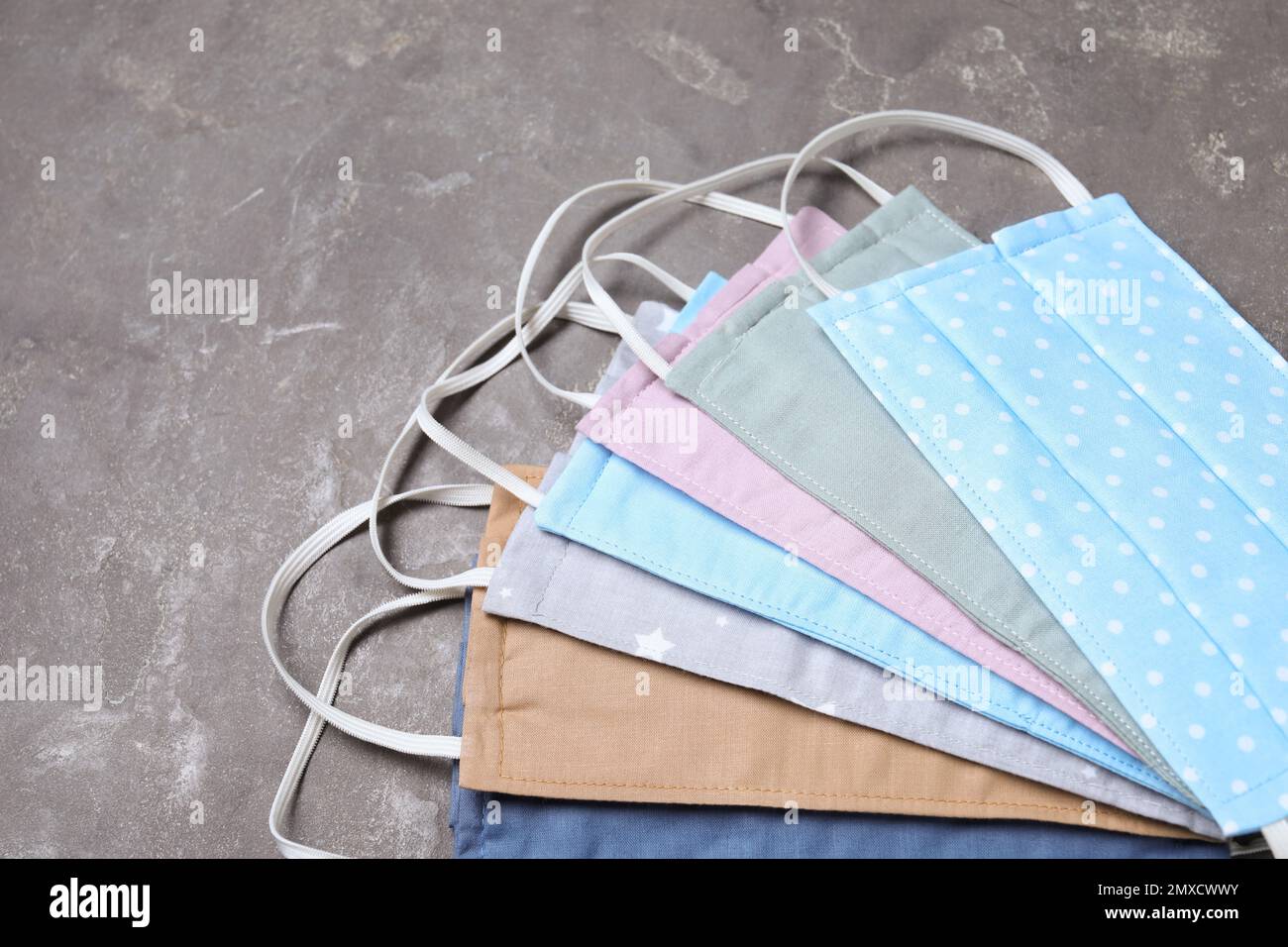 Homemade protective masks on grey stone background, closeup. Sewing ...