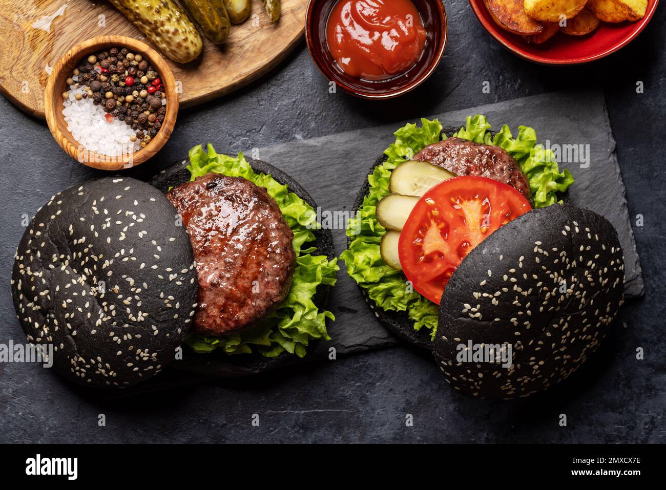 Homemade beef burgers with black buns and french fries. Flat lay Stock ...