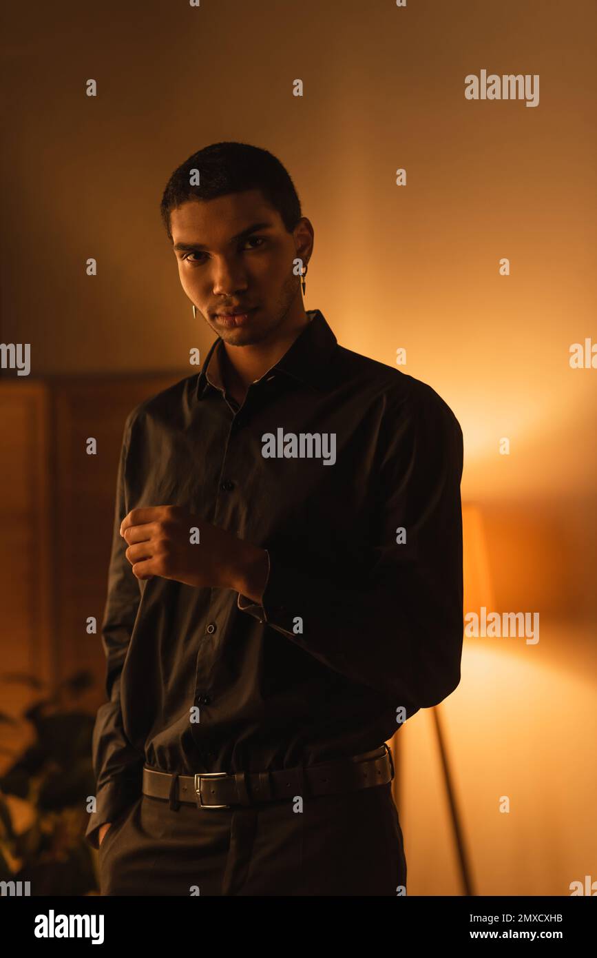 african american guy in black shirt holding hand in pocket of pants and ...