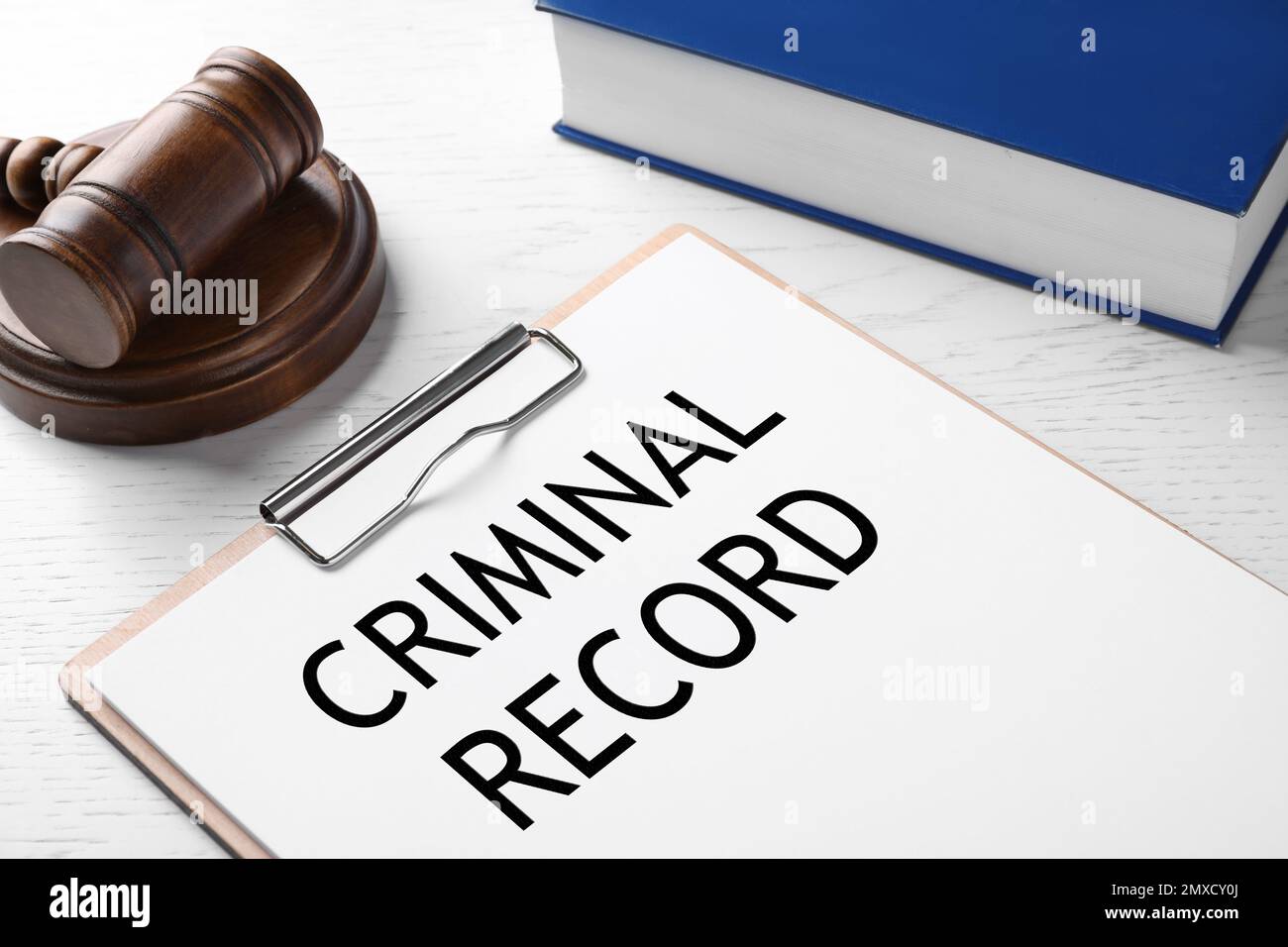 Clipboard with words CRIMINAL RECORD and gavel on white wooden table ...