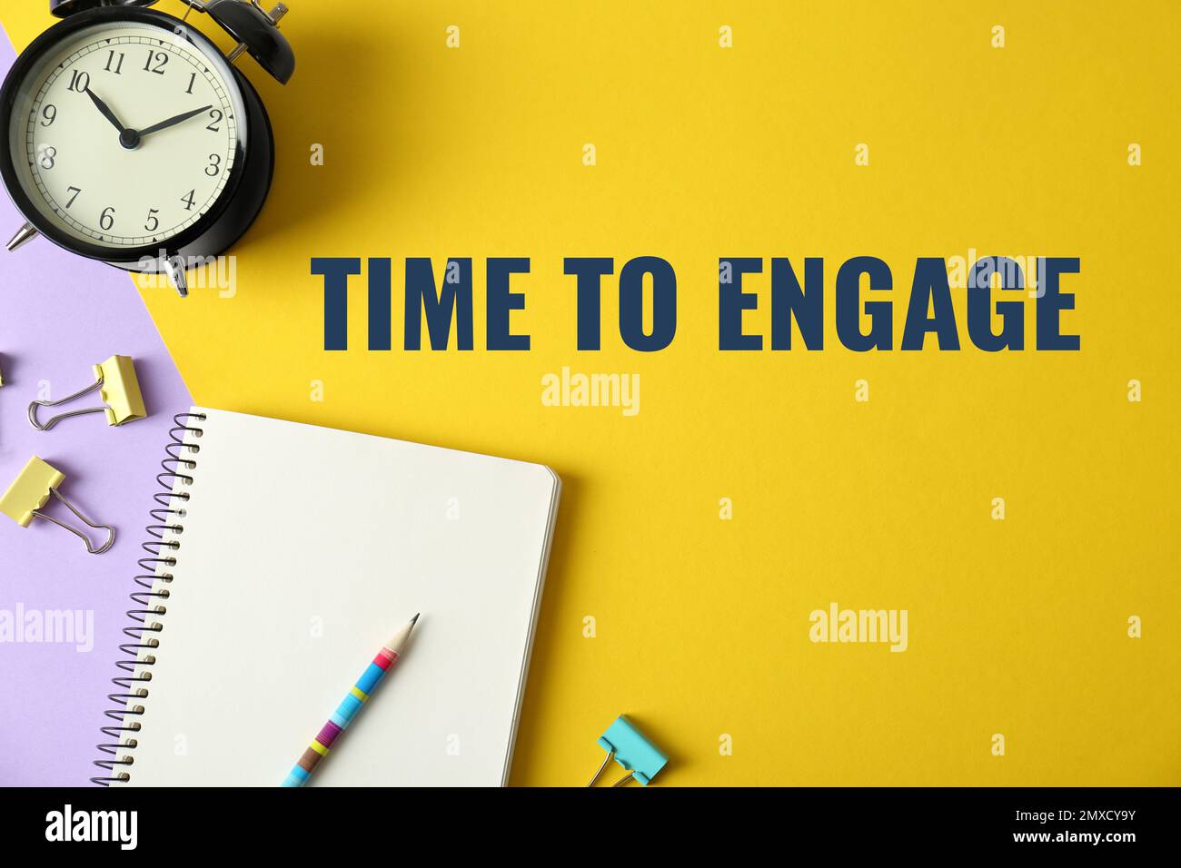 Alarm clock, stationery and phrase TIME TO ENGAGE on yellow background ...