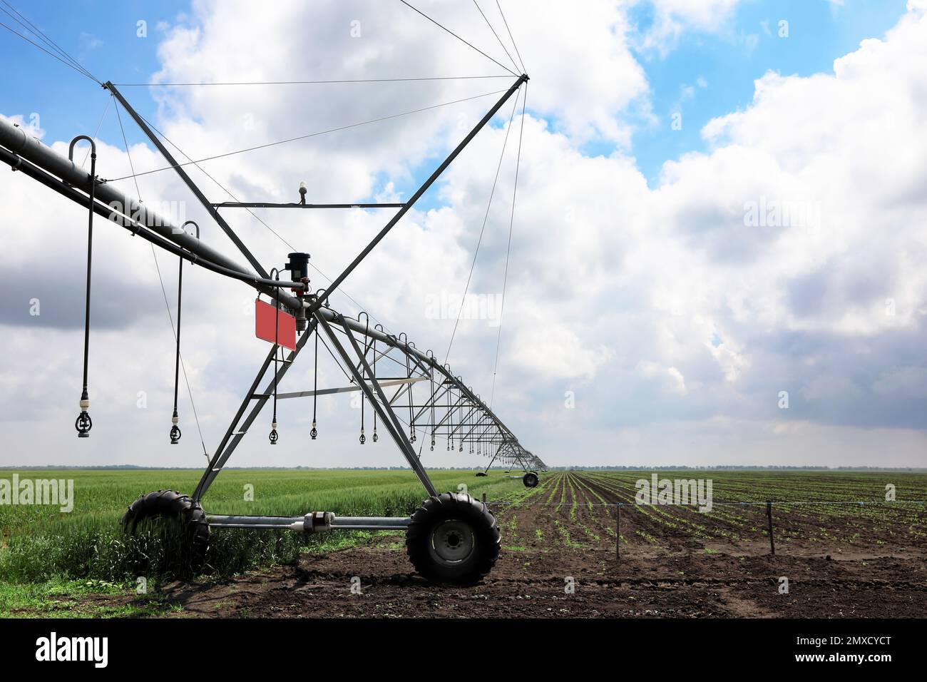 Modern irrigation system in field under cloudy sky. Agricultural ...
