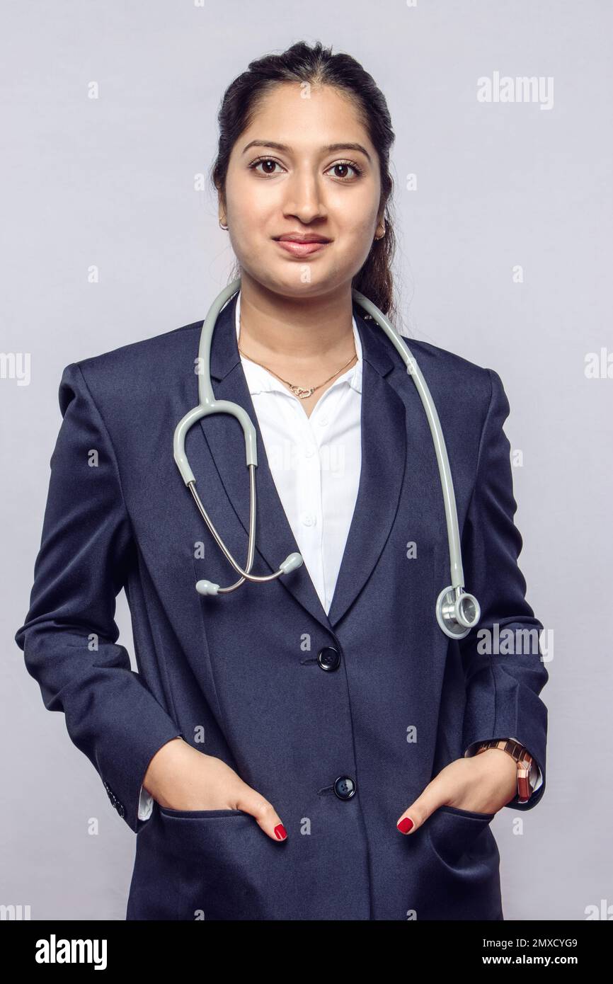 A vertical shot of a confident young Indian female doctor in a suit ...
