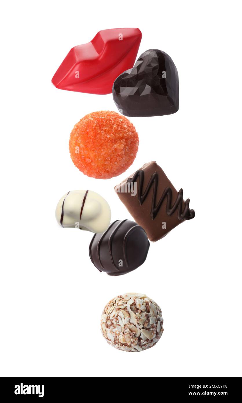 Different chocolate candies falling on white background Stock Photo - Alamy