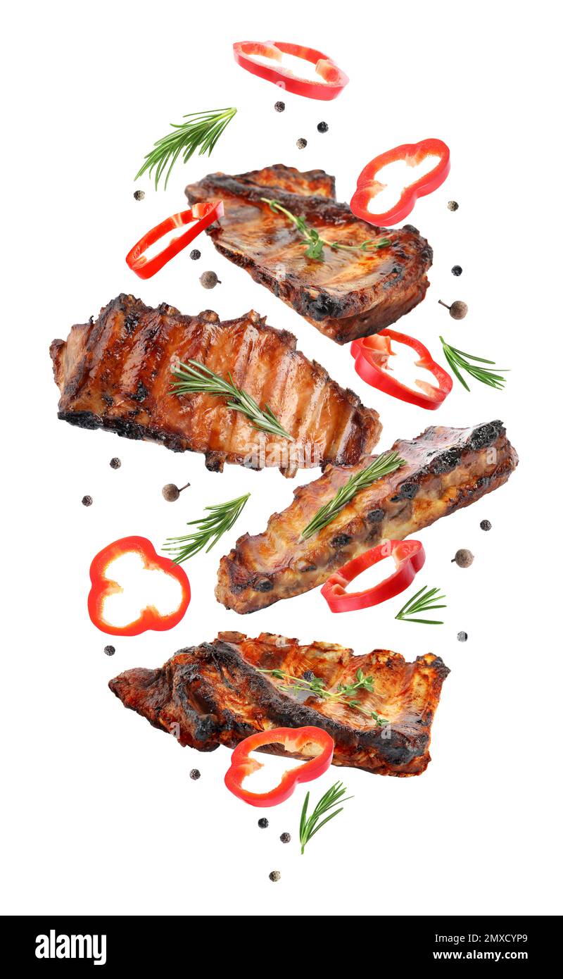 Delicious grilled meat and other ingredients falling on white ...